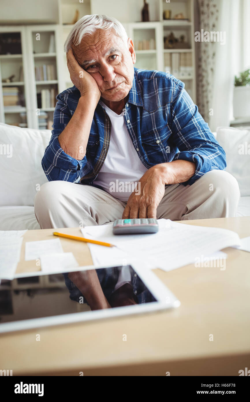 Worried senior man sitting on a sofa Stock Photo - Alamy