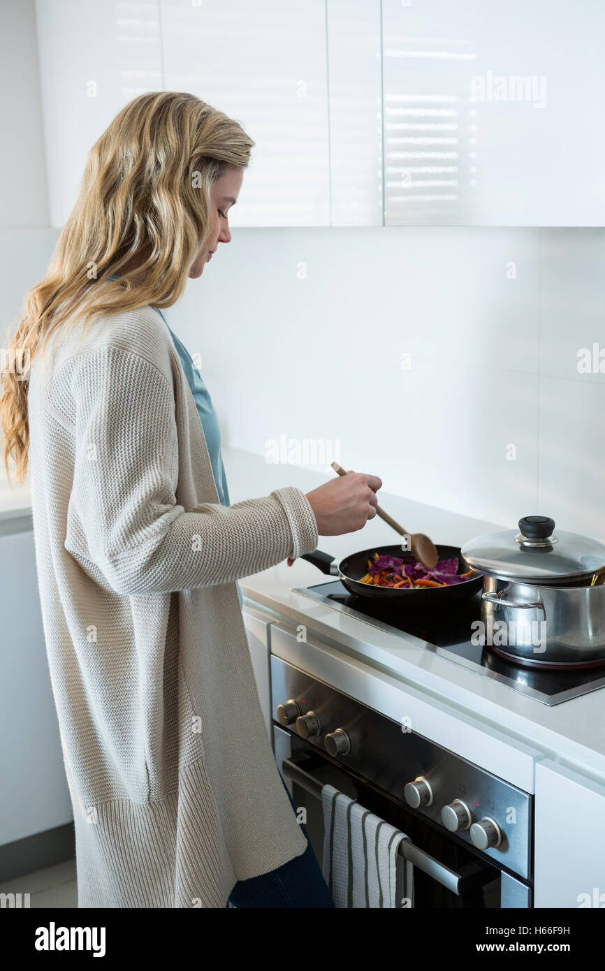 Woman cooking food in kitchen hi-res stock photography and images - Alamy