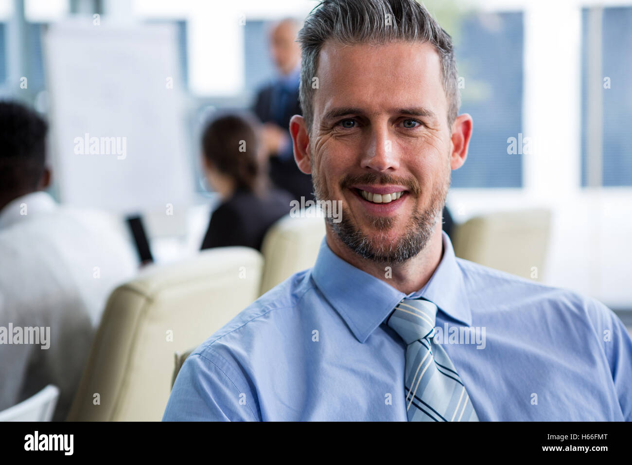 Smiling businessman sitting in office Stock Photo - Alamy