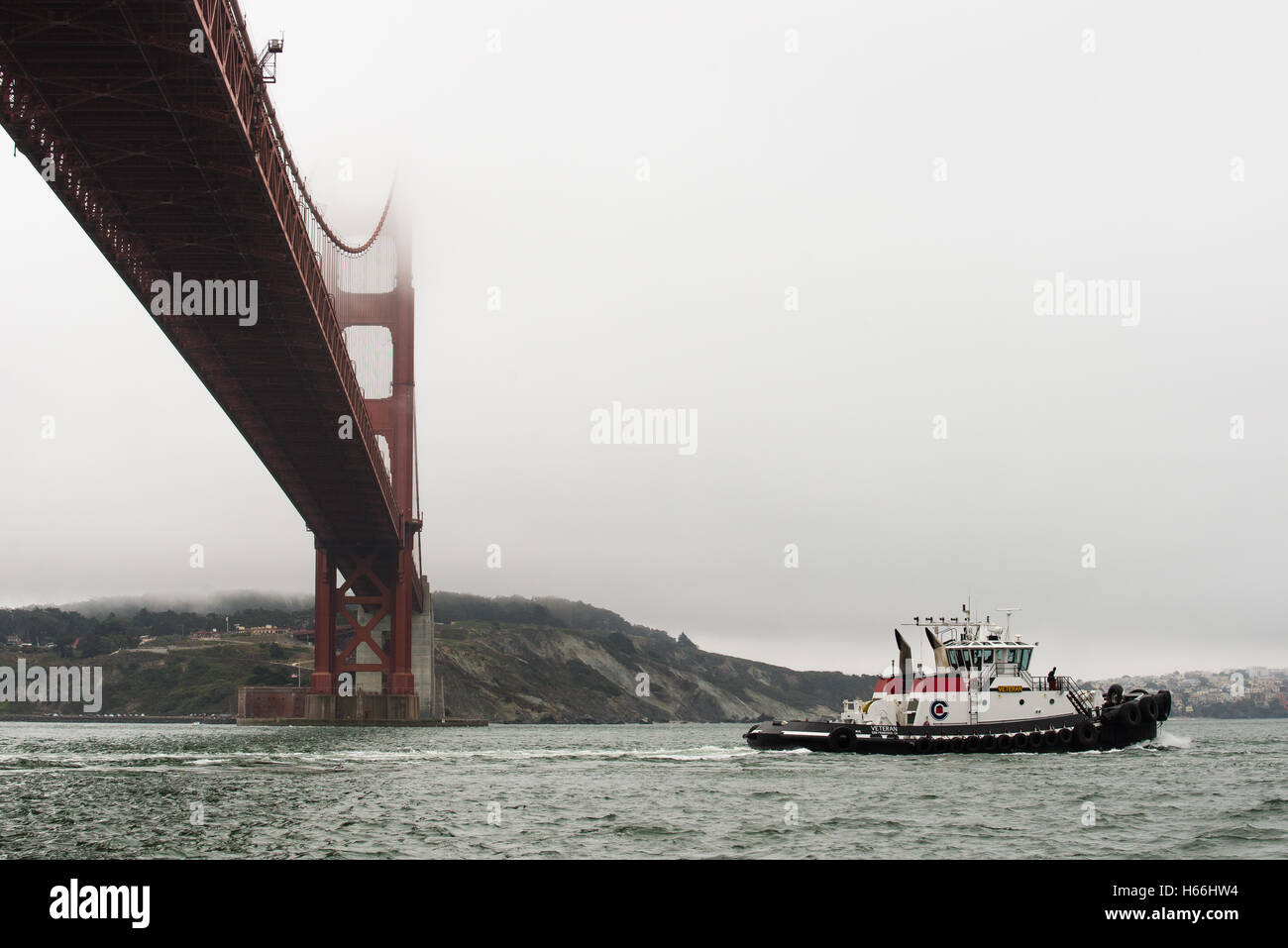 Tugboat passing under the Golden Gate Bridge Stock Photo - Alamy