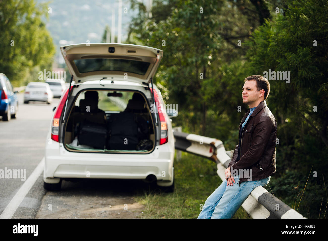 Road trip break after long drive. Man waiting for someone sitting on ...