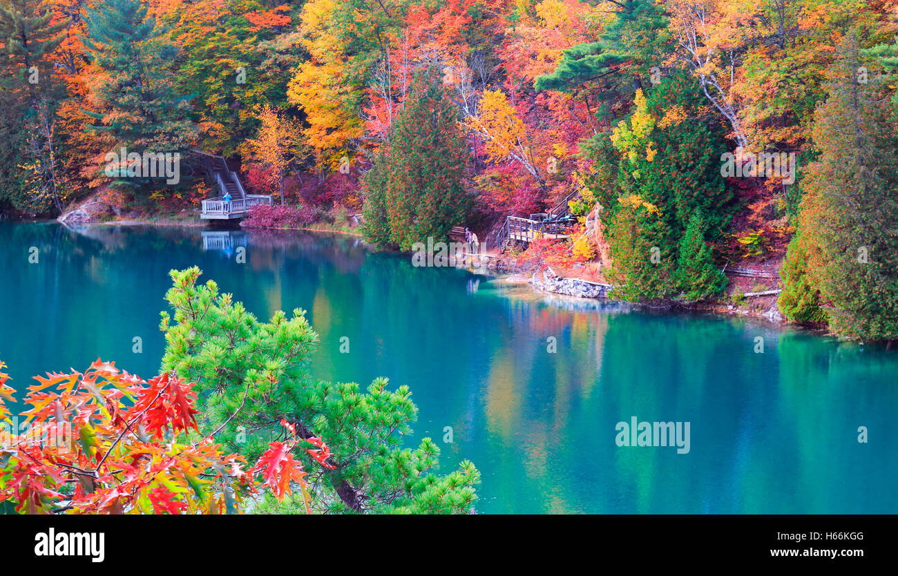 Fall colors and reflections with tourists looking and taking photos at ...