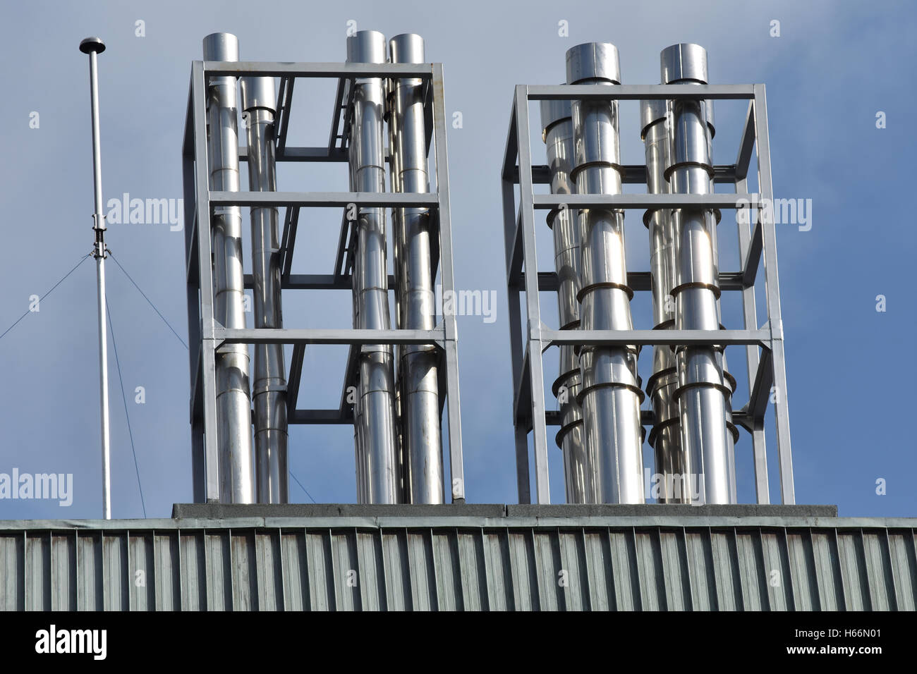 Circular metal chimneys supported by metal cages Stock Photo - Alamy