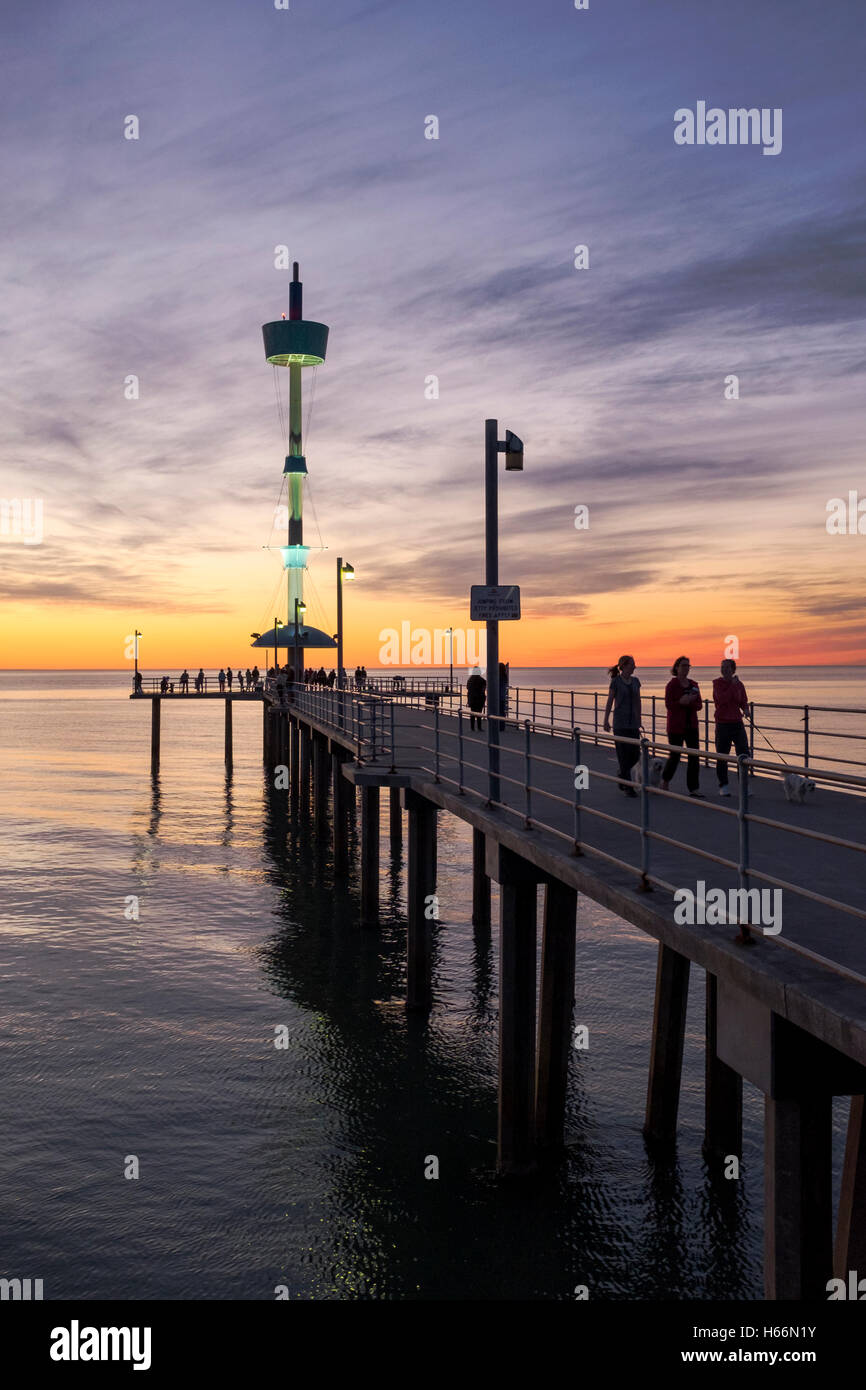 People enjoy a sunset stroll along the jetty at Adelaide's Brighton ...