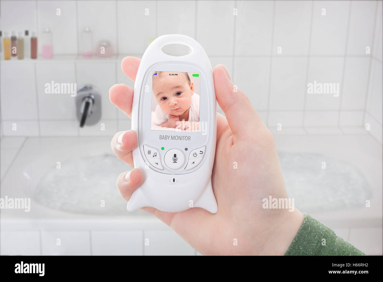 Parent checking baby through baby monitor when taking a bath Stock ...