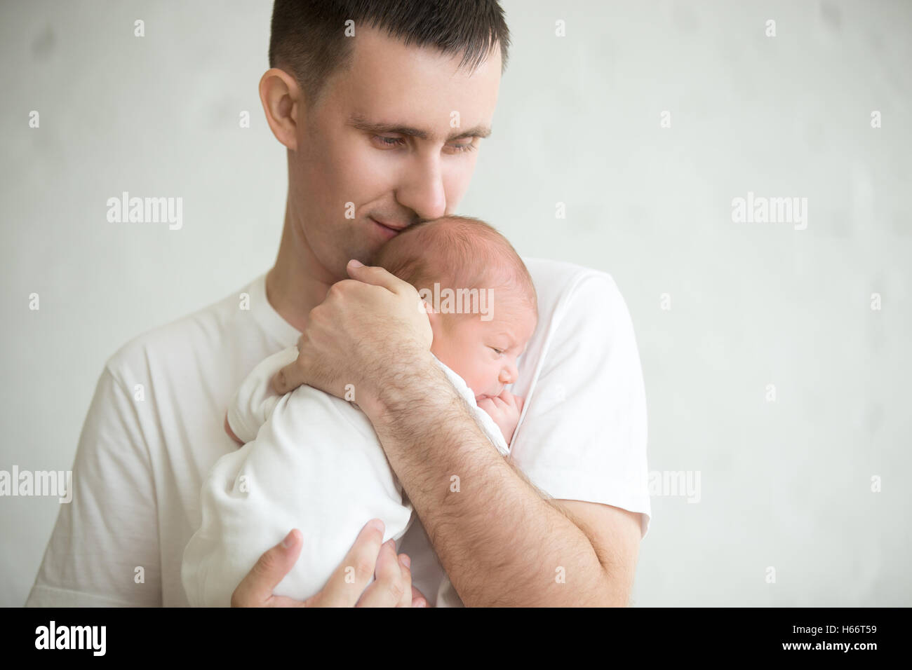 Portrait of man holding his baby Stock Photo - Alamy