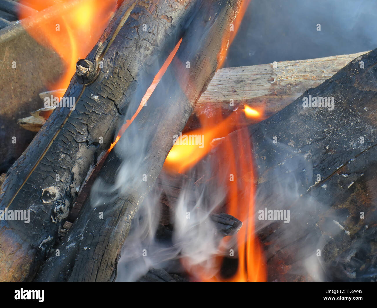 Logs lit on fire for a toasty campfire Stock Photo - Alamy