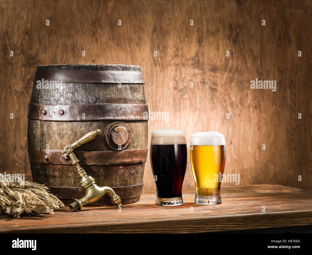 Glasses of beer and ale barrel on the wooden table. Craft brewery Stock ...