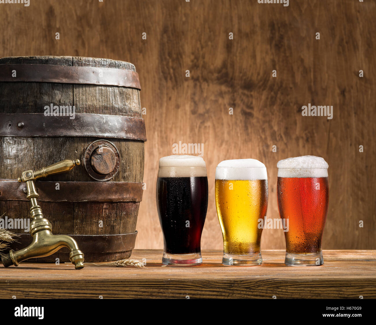 Glasses of beer and ale barrel on the wooden table. Craft brewery Stock ...