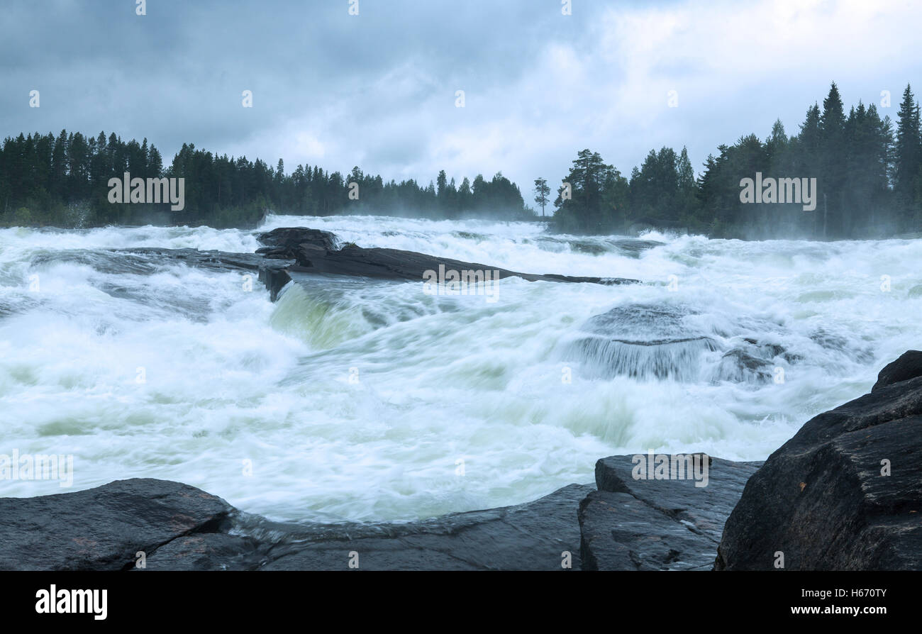 Cascades of water in the big river. Rocks and cliffs break the speed ...