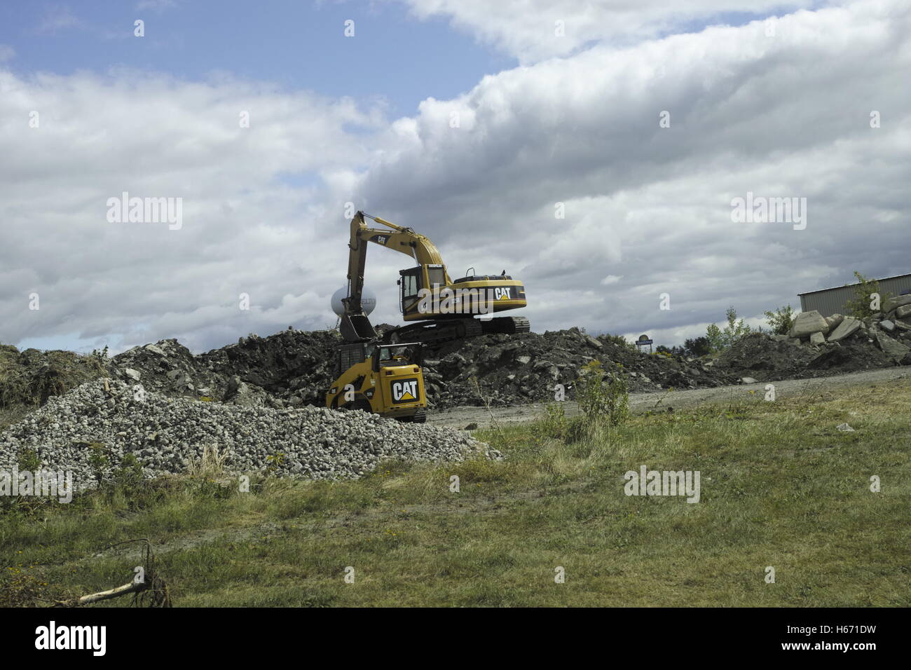 excavator digging large pile of dirt Stock Photo - Alamy