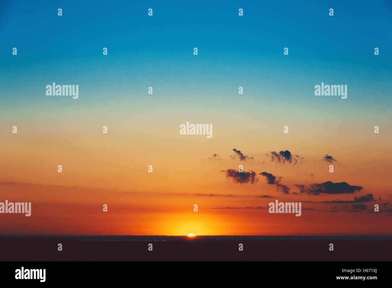 Beautiful blazing sunset landscape at over the meadow and orange sky ...