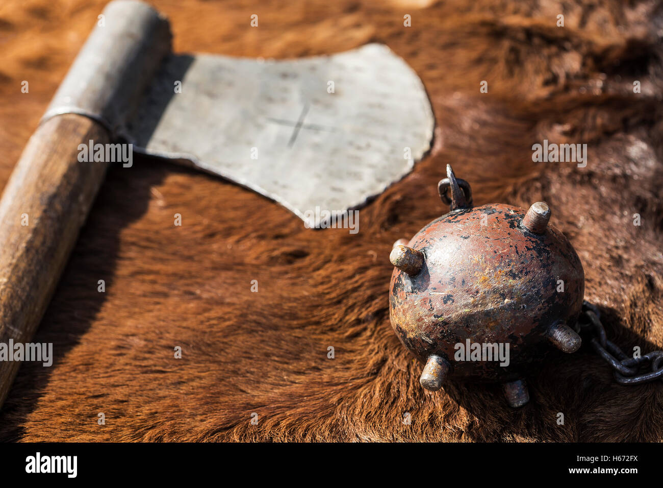 Metal axe and a mace on a cow hide Stock Photo - Alamy