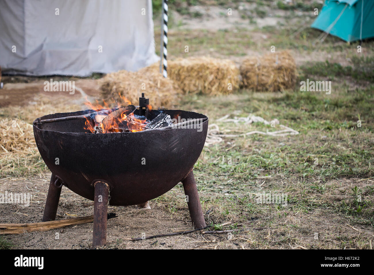 Small burning camp fire in a metal container Stock Photo - Alamy