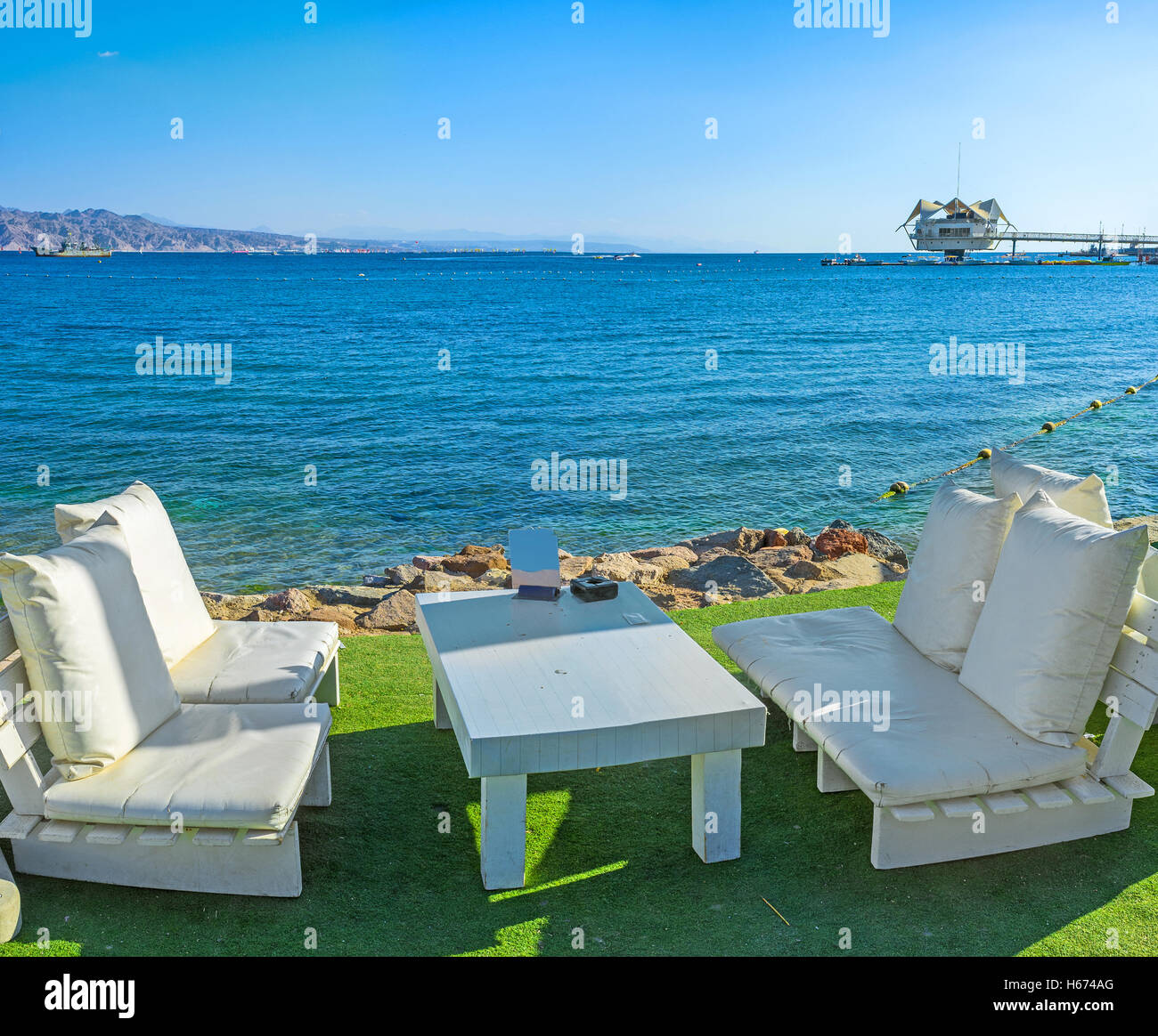 The cozy white benches in the beach cafe on the seashore with the view ...
