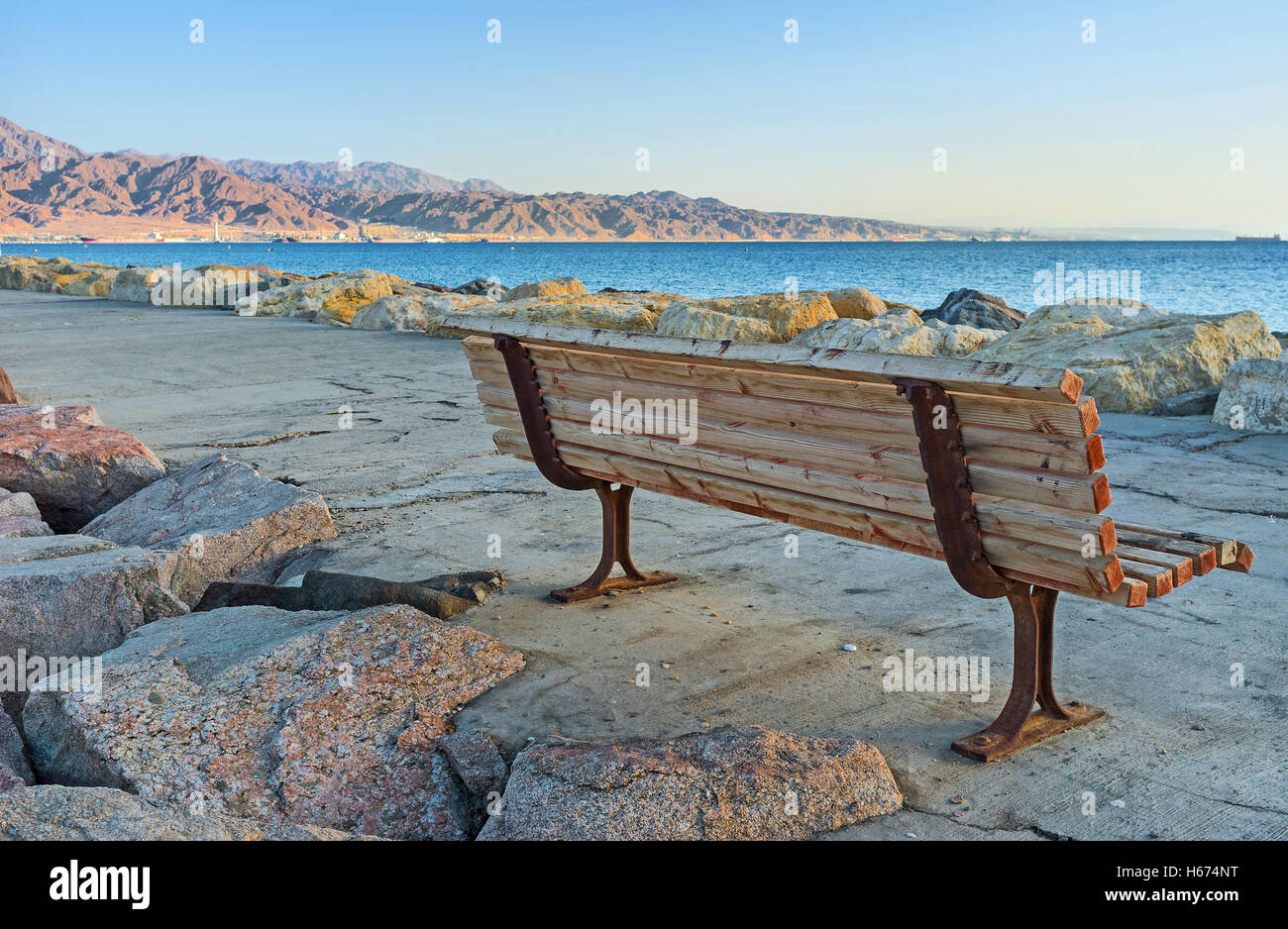 The new harbor's pier is equipped with the wooden benches, faced on sea ...