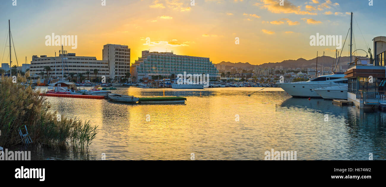 The colorful sunset sky over the Lagoona of Eilat reflects in calm ...