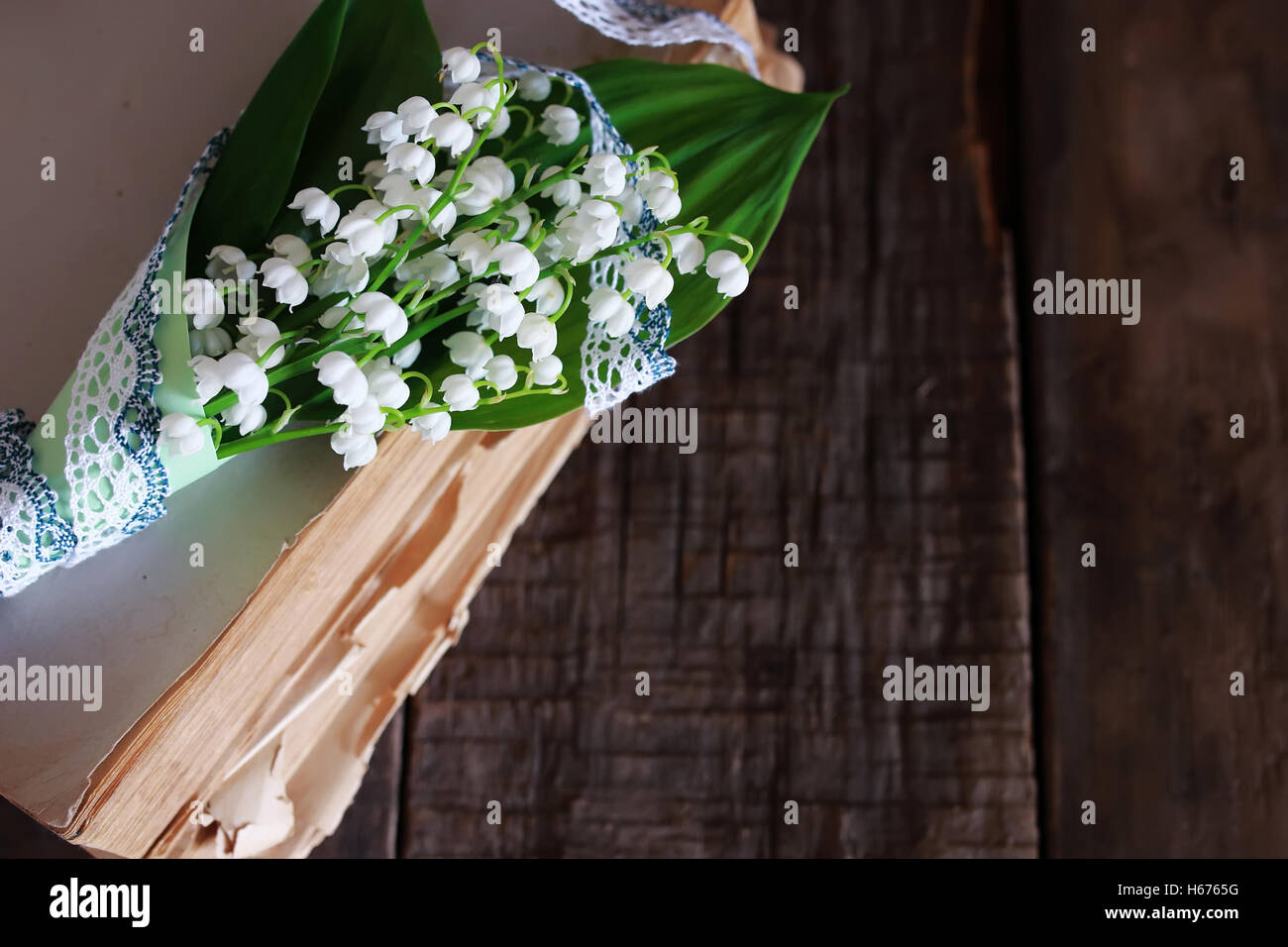 bouquet of fresh lilies of the valley and retro book Stock Photo - Alamy