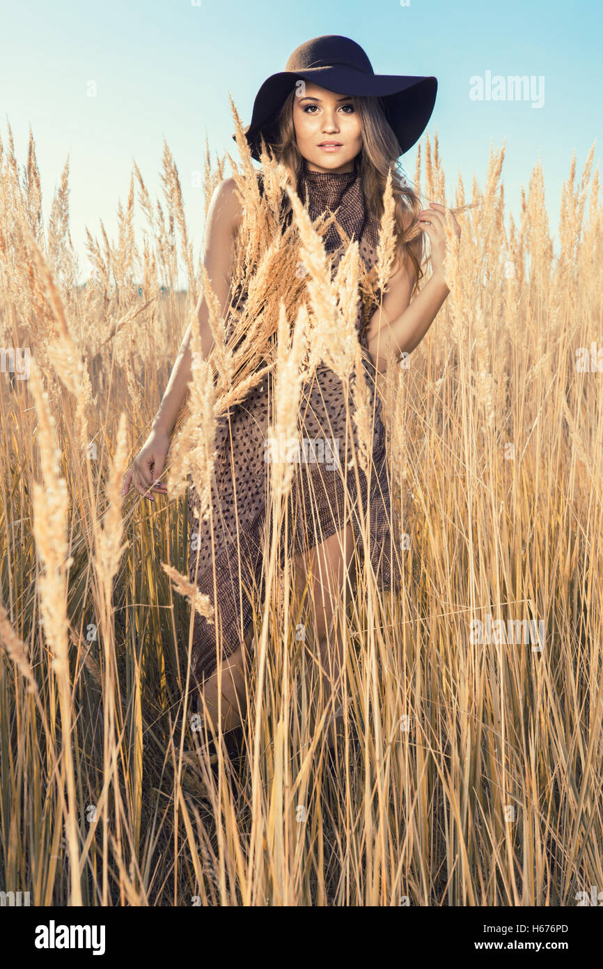 Beautiful model walking through tallgrass meadow at noon Stock Photo ...