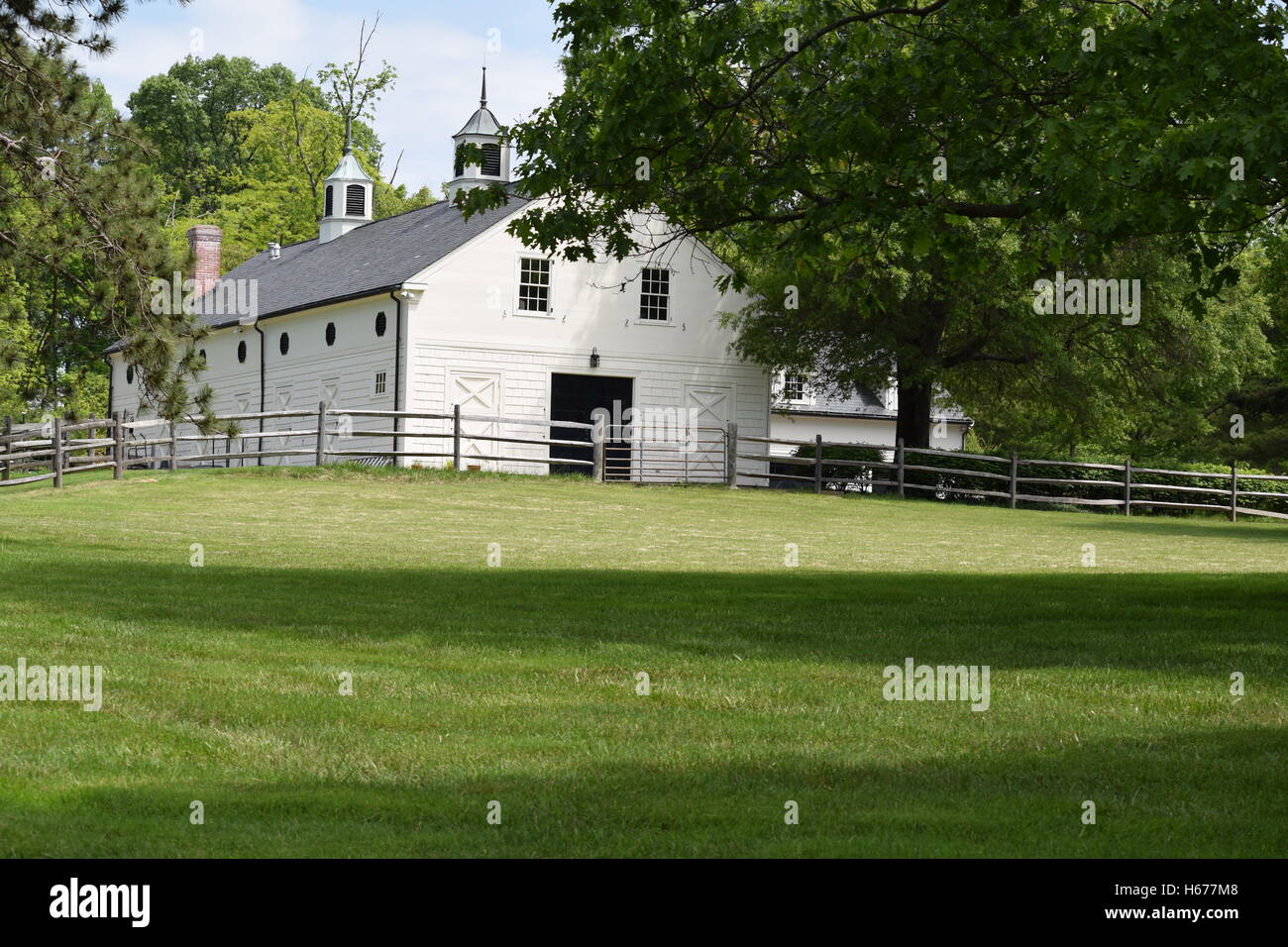 White barn with shade trees and green lawn Stock Photo - Alamy