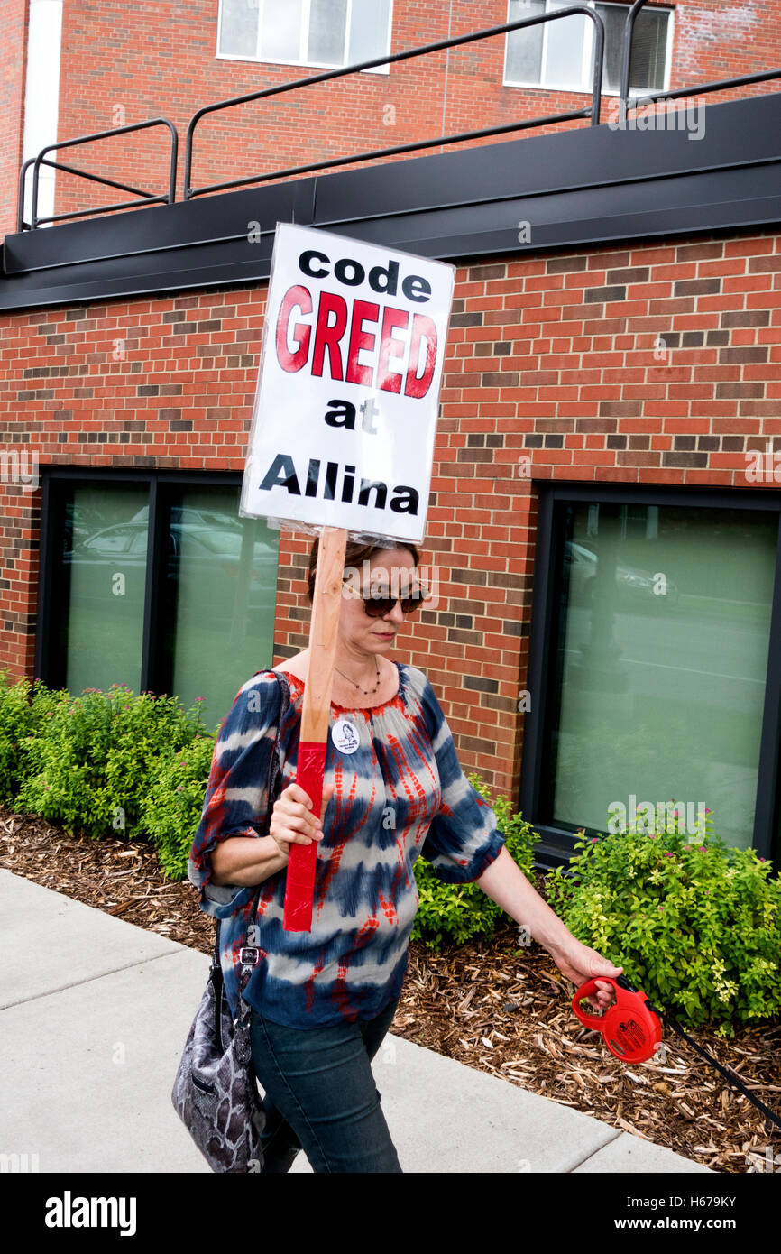 Striking nurse carrying a "Code Greed" sign protesting new health ...