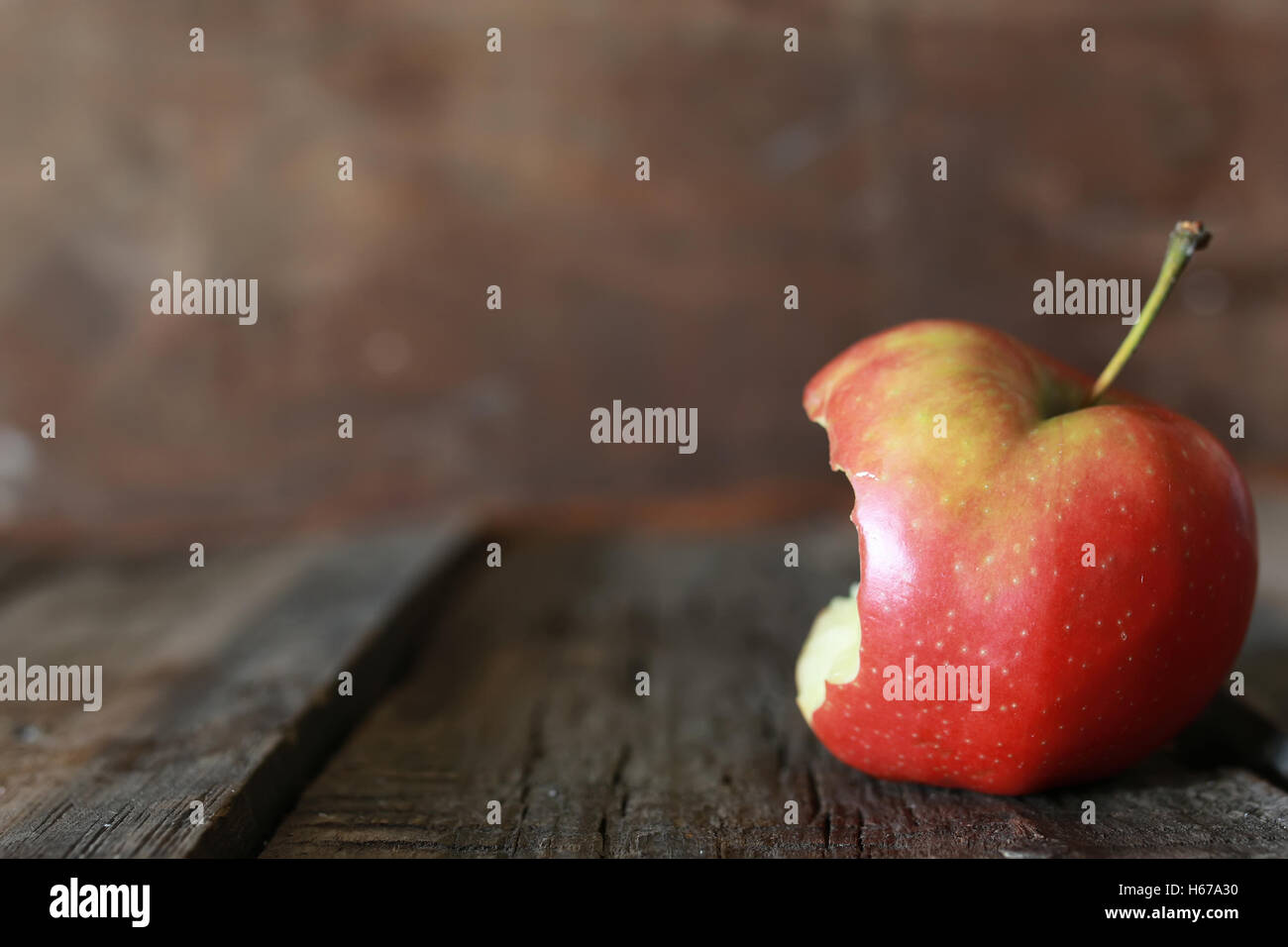 bitten apple on a wooden background Stock Photo - Alamy