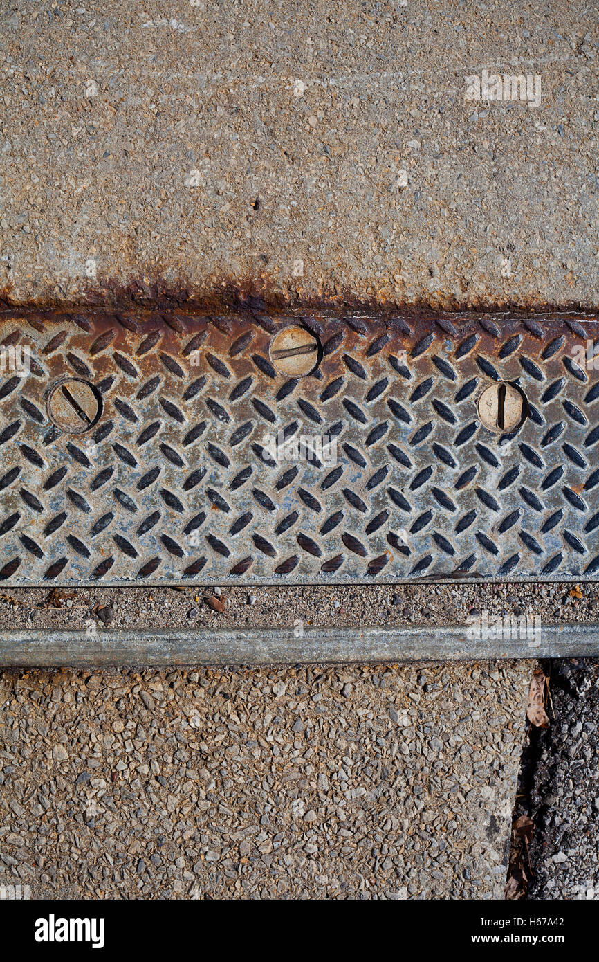 Three screw heads in metal grating Stock Photo - Alamy