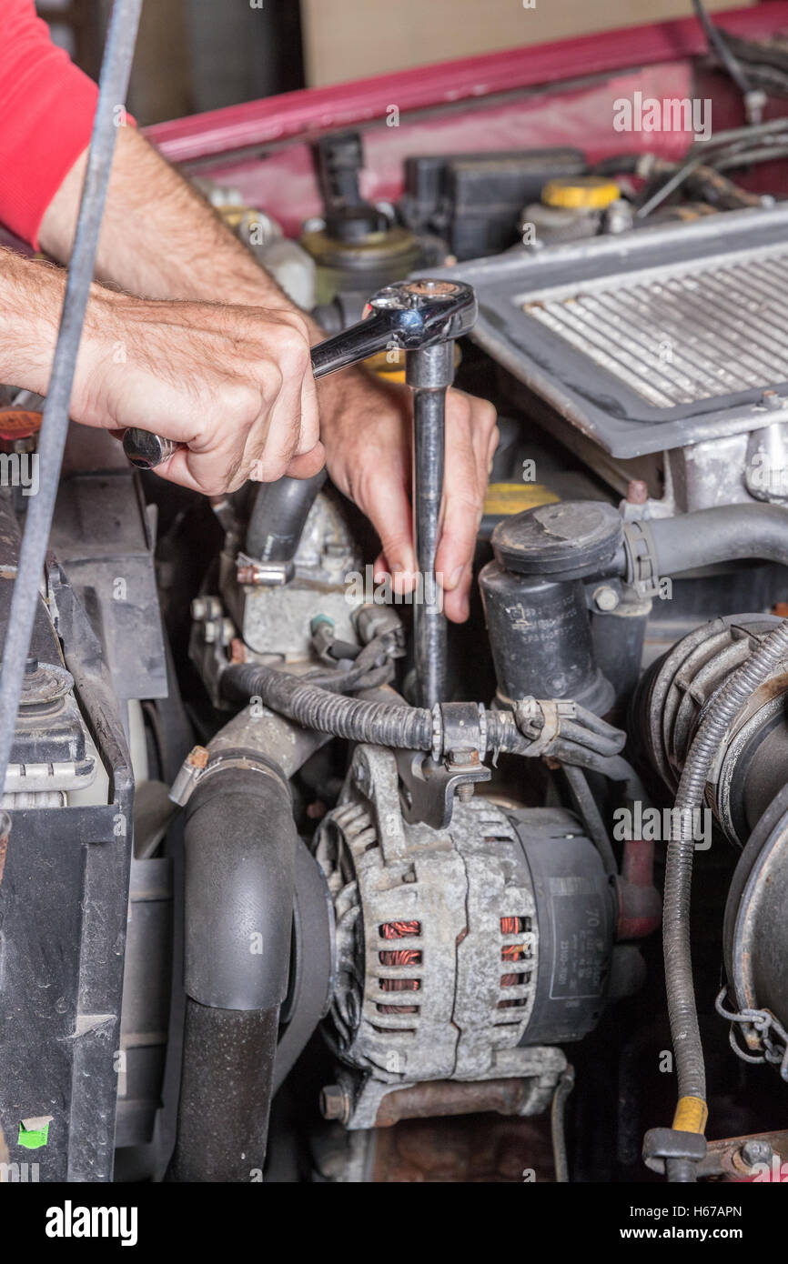 Mechanic working on a car engine in a garage Stock Photo - Alamy