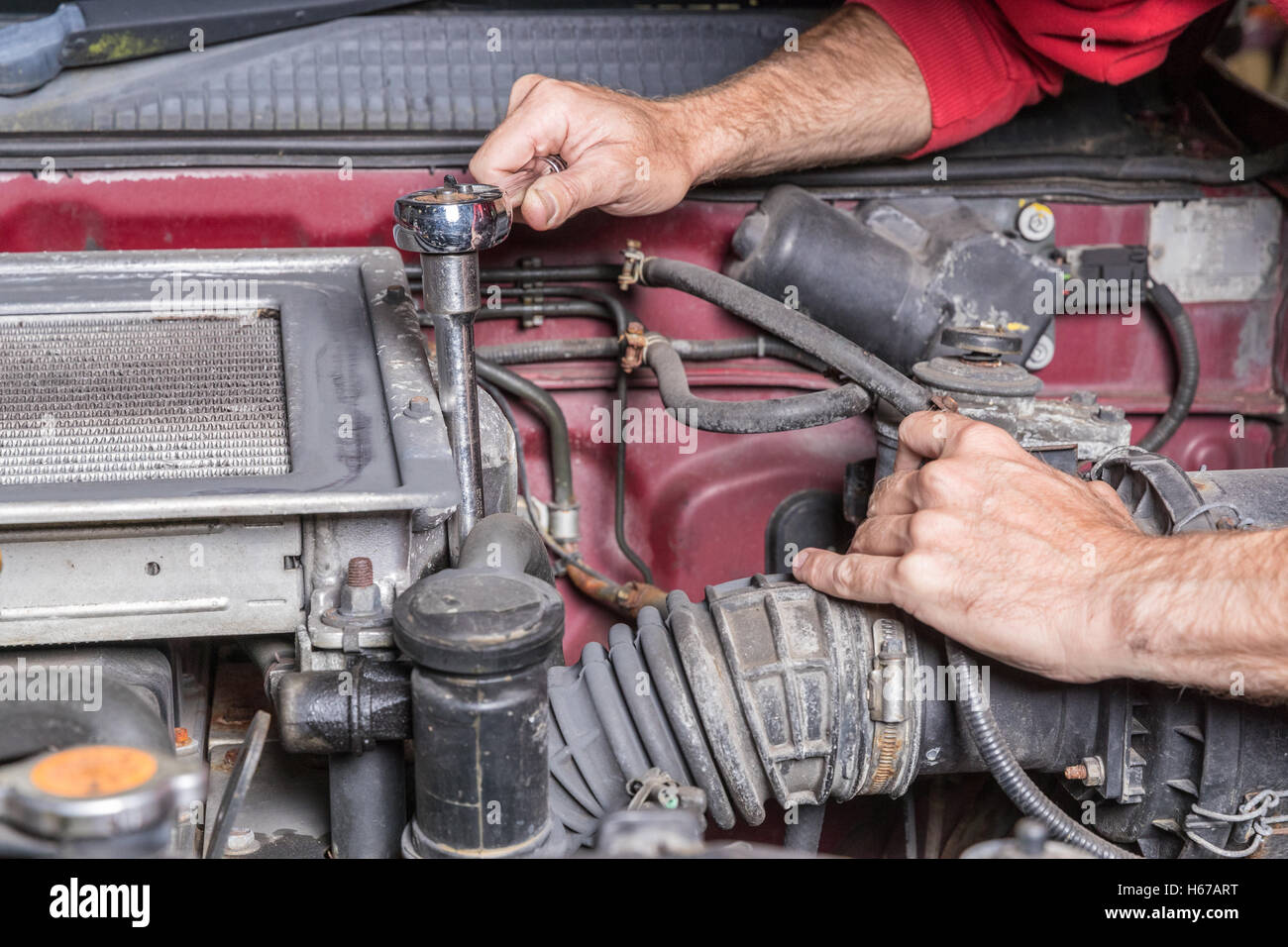 Mechanic working on a car engine in a garage Stock Photo - Alamy