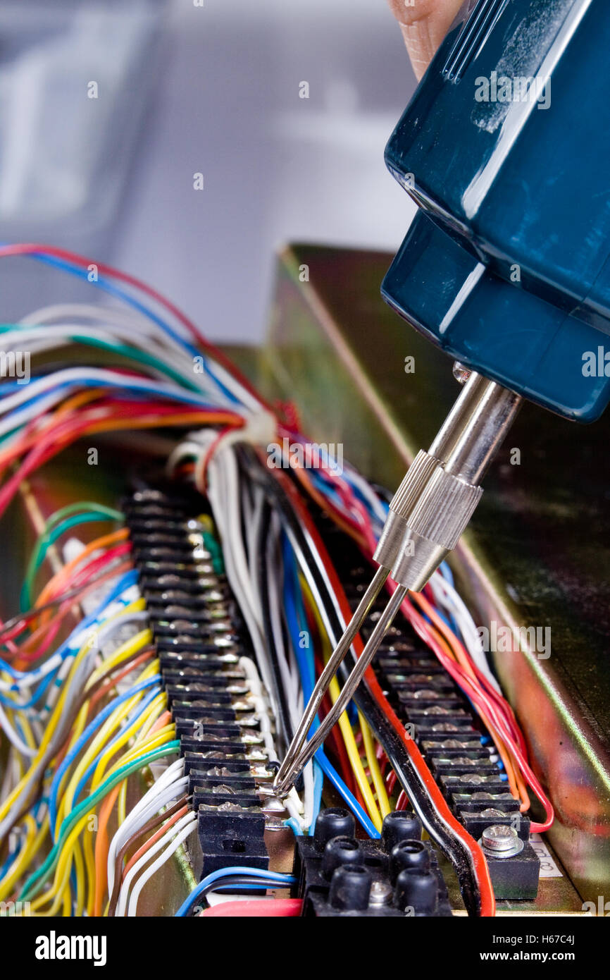 electrician at work with an electric device Stock Photo - Alamy