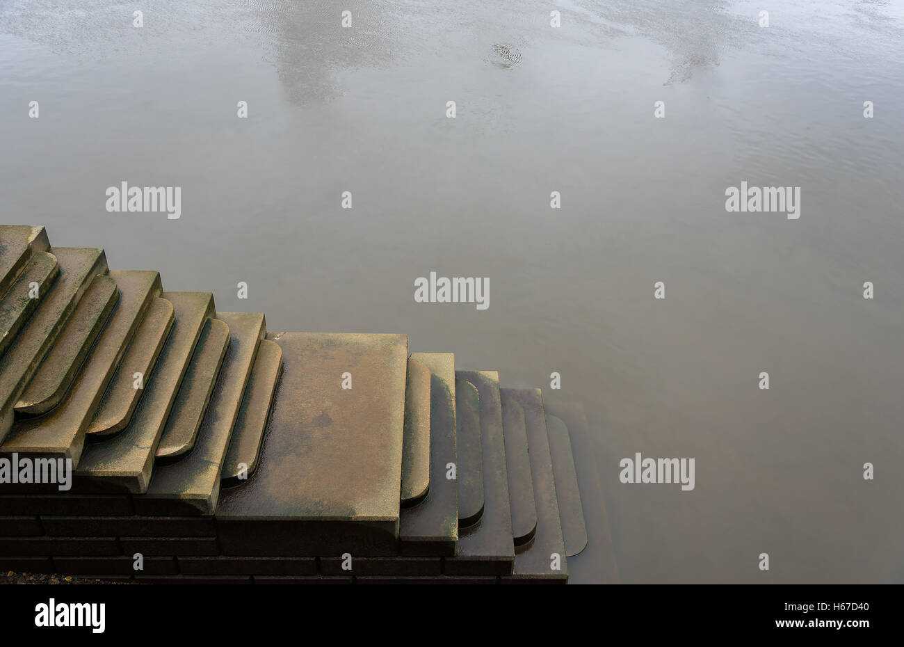 Stone steps leading down into calm still water sinking below the ...