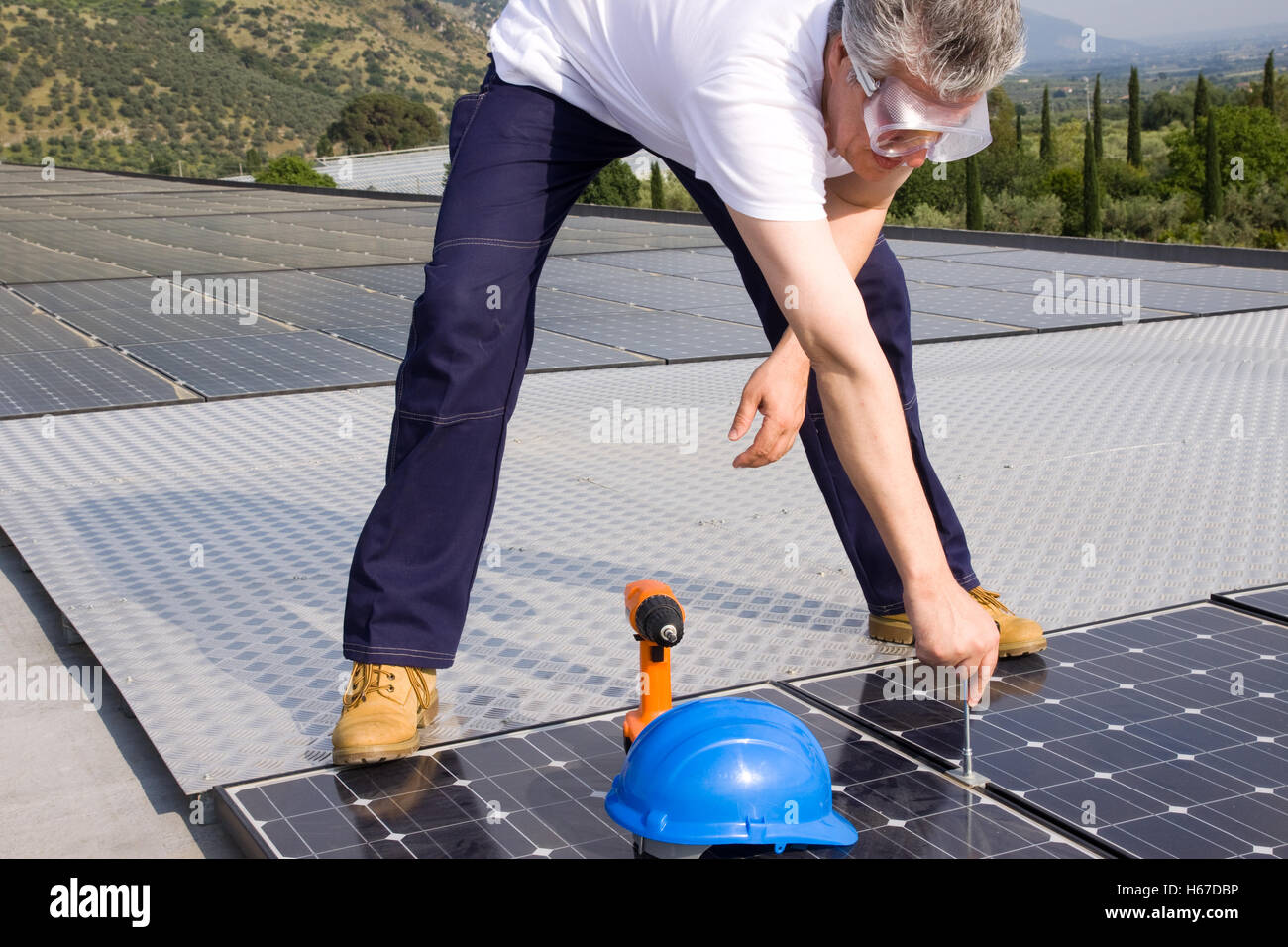 skilled woker fitting a photovoltaic plant on a roof Stock Photo - Alamy