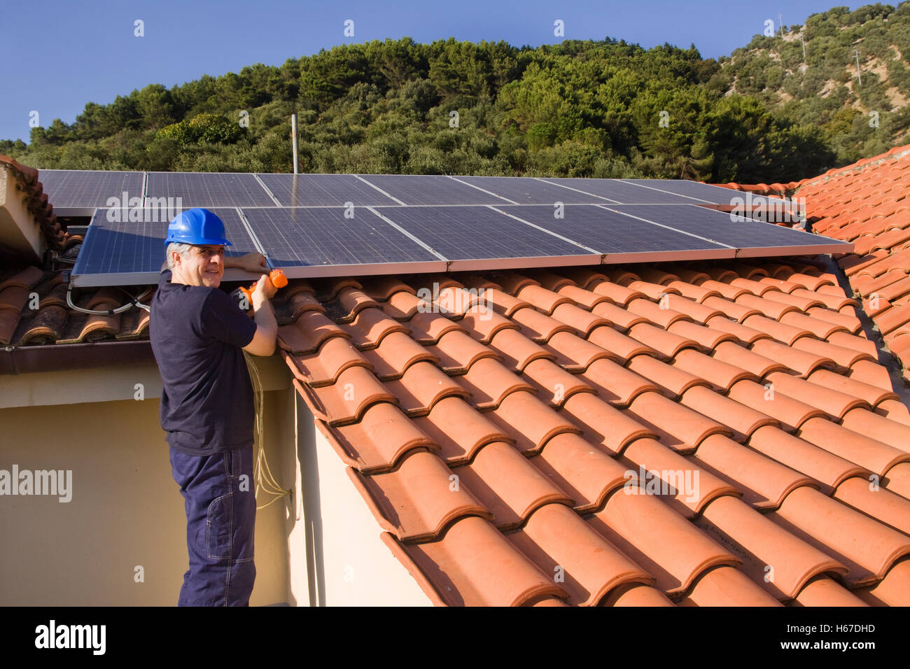 skilled worker fitting a photovoltaic plant on a roof Stock Photo - Alamy