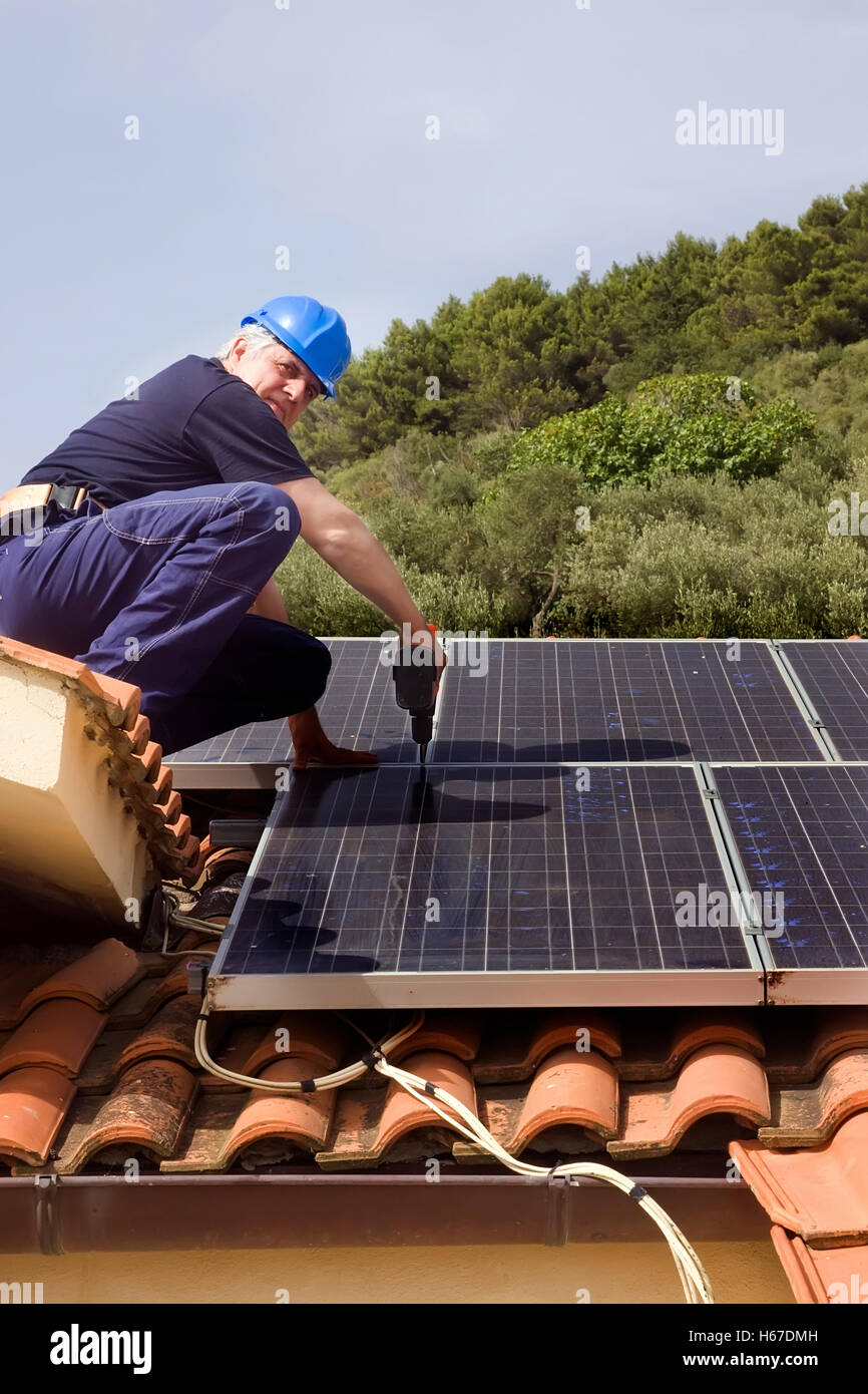 skilled worker fitting a photovoltaic plant on a roof Stock Photo - Alamy