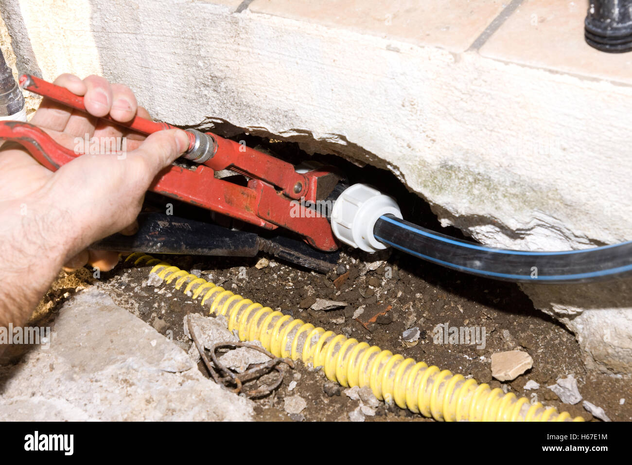 plumber fitting some pipes in a building site Stock Photo - Alamy