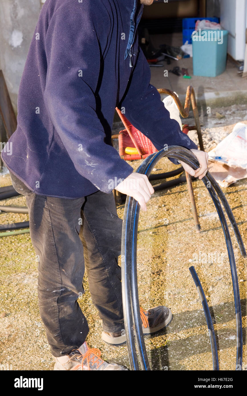 plumber fitting some pipes in a building site Stock Photo - Alamy