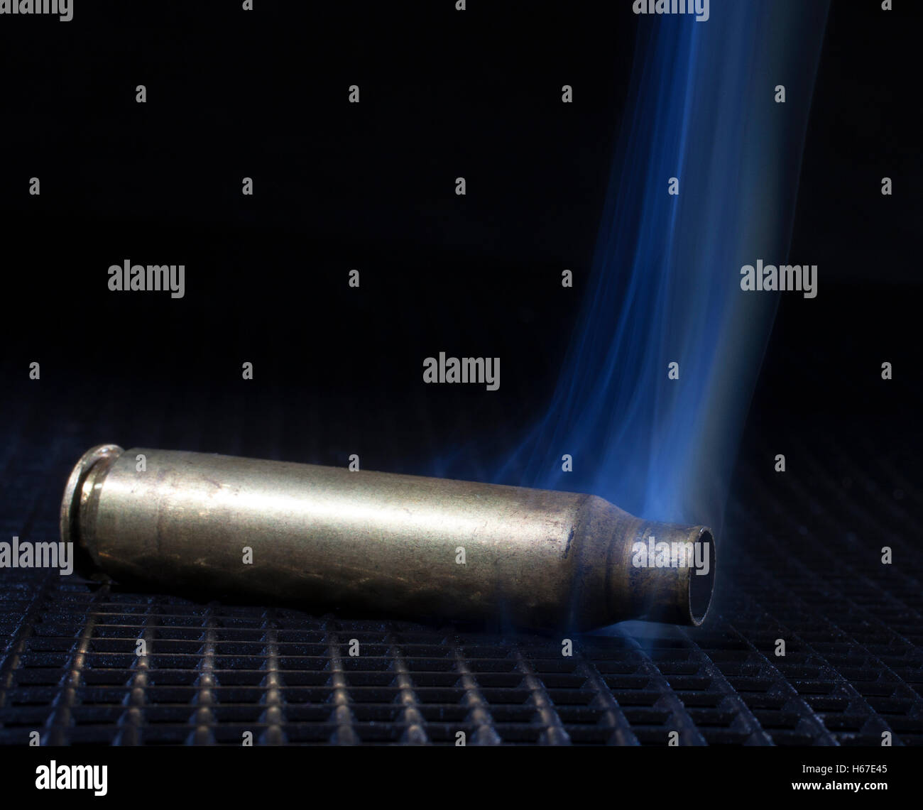Empty rifle brass on a black grate that has smoke coming out Stock ...