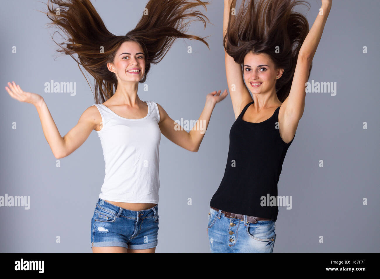 Two young women jumping Stock Photo - Alamy