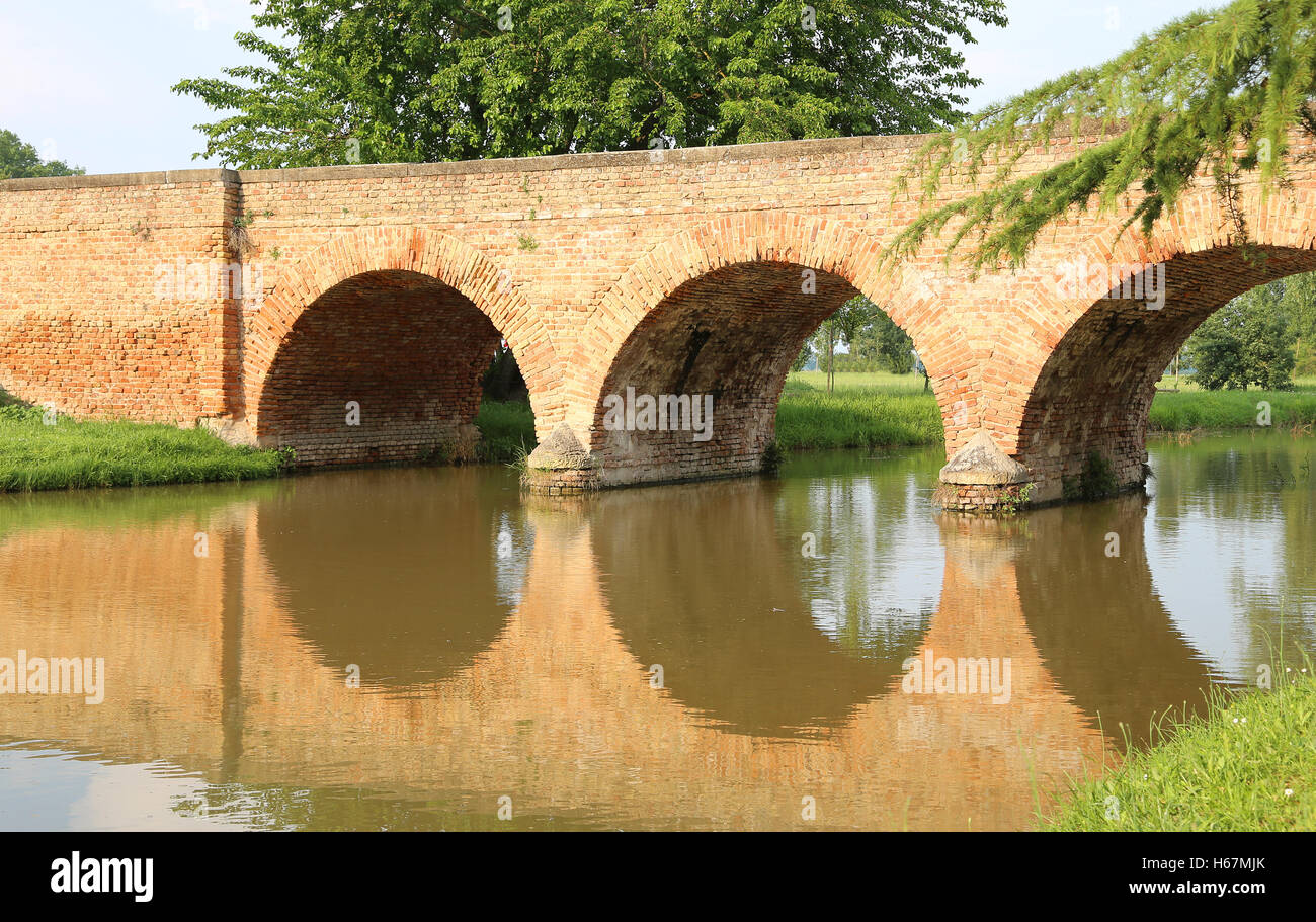 medieval bridge made of red brick with three arches over the river ...