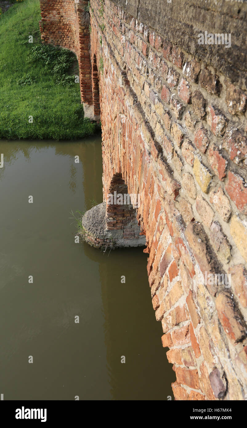 detail of a medieval bridge made of red brick on the river in Europe ...