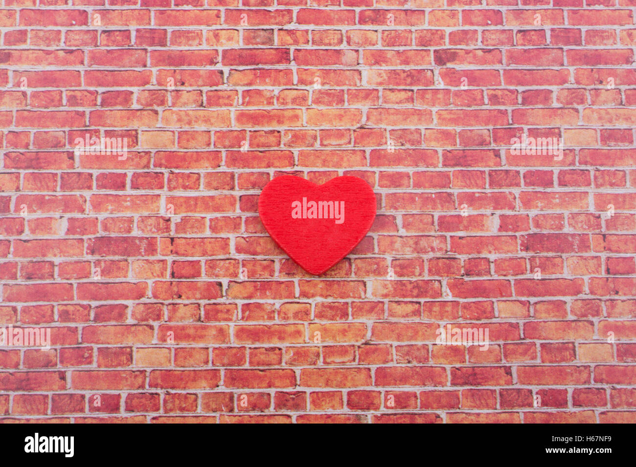 Red heart shape icon on a brick wall Stock Photo - Alamy