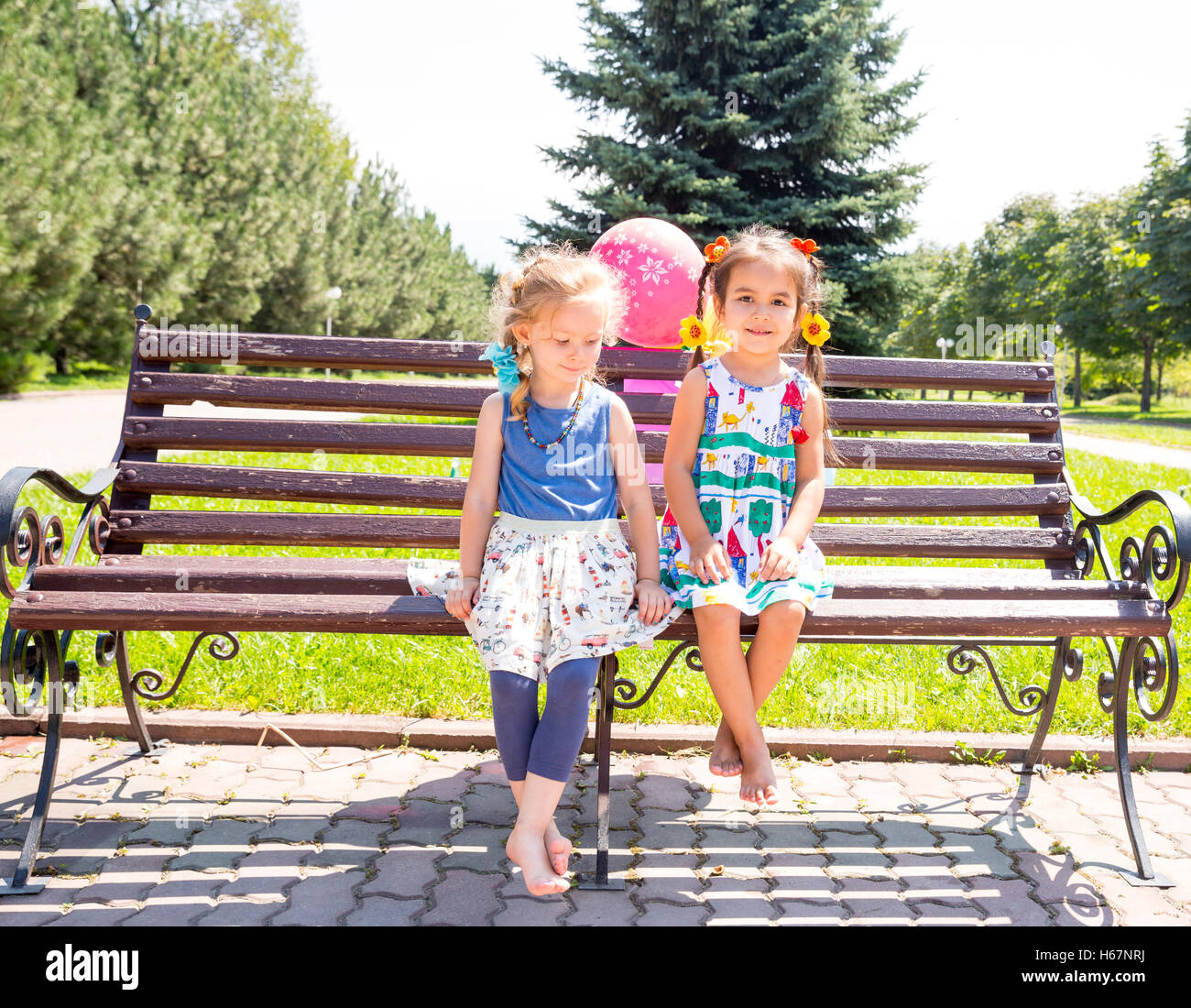Two girlfriends. Adorable little children in park Stock Photo - Alamy