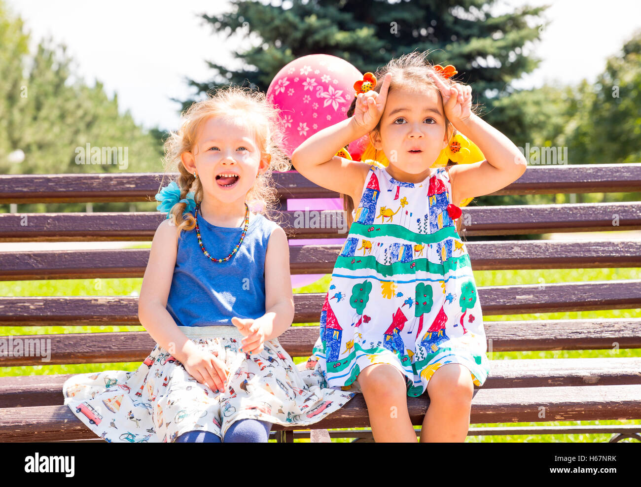 Two girlfriends. Adorable little children in park Stock Photo - Alamy