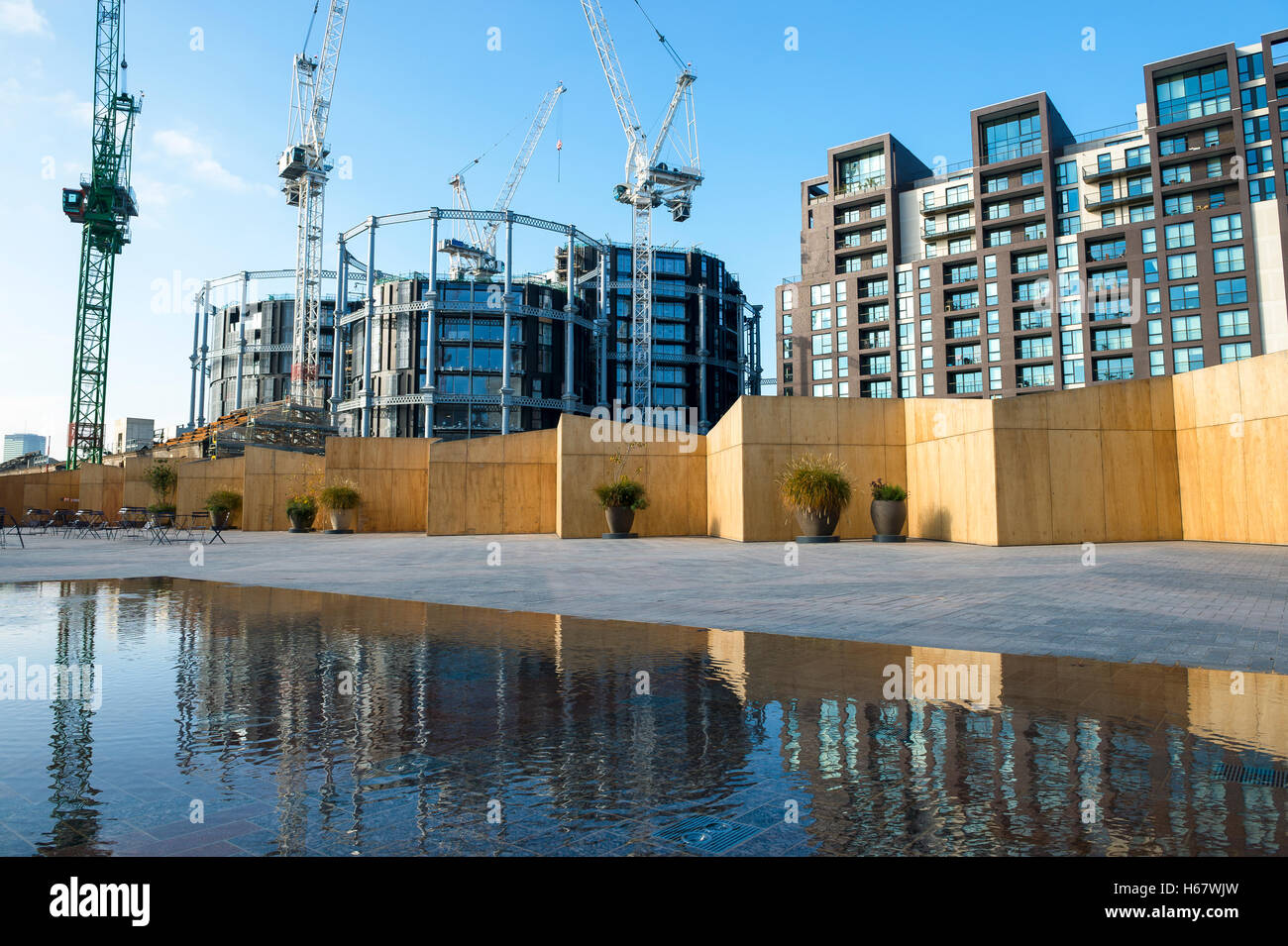 Urban construction scene with cranes and wooden boards separating the ...