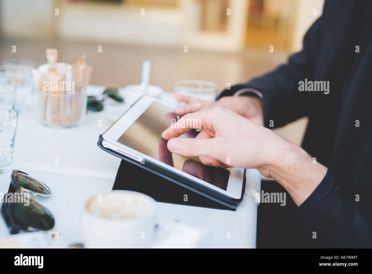 Close up on the hands of young men tapping the touch screen of a tablet ...