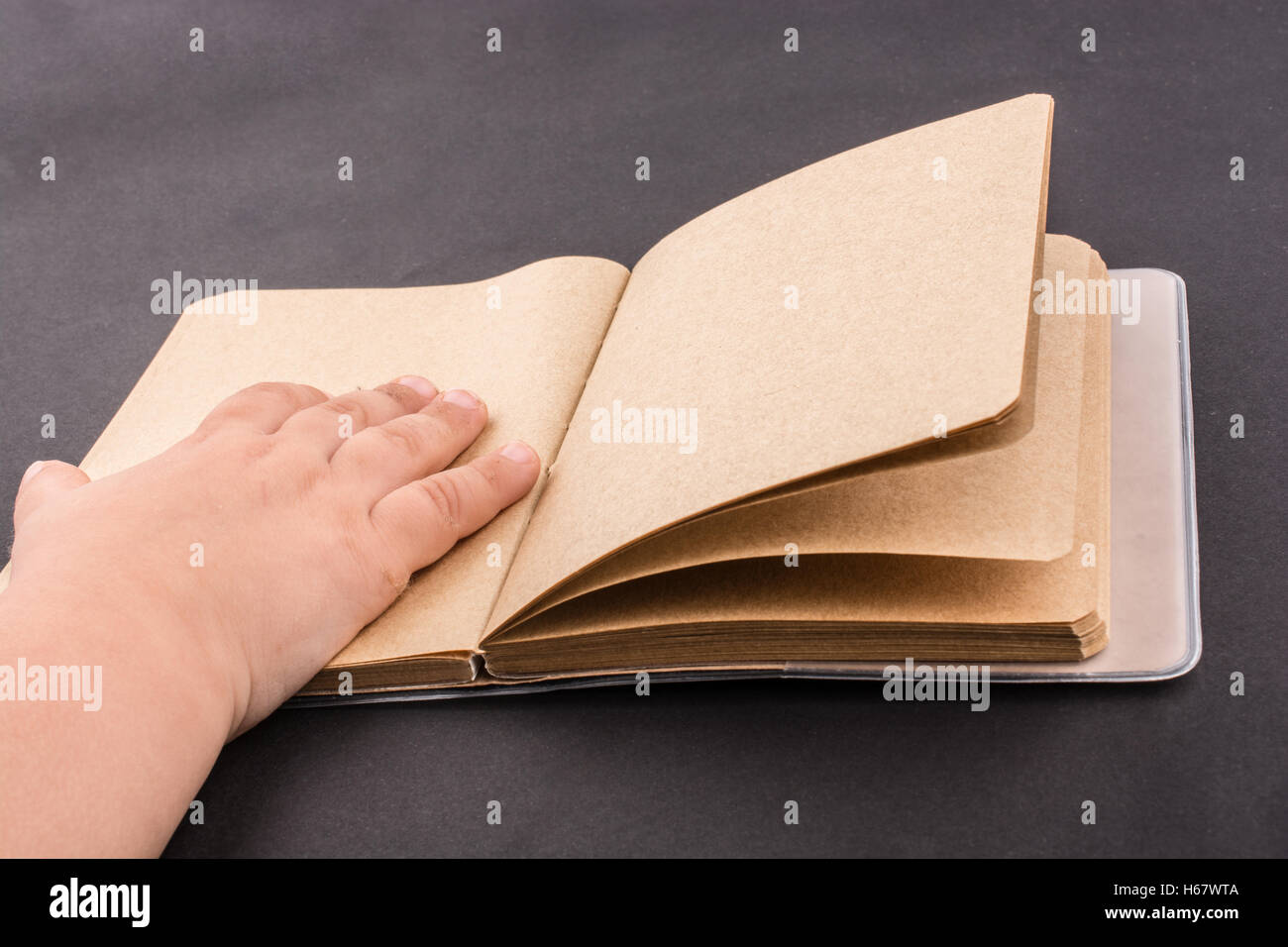 Hand holding brown color notebook on a white background Stock Photo - Alamy