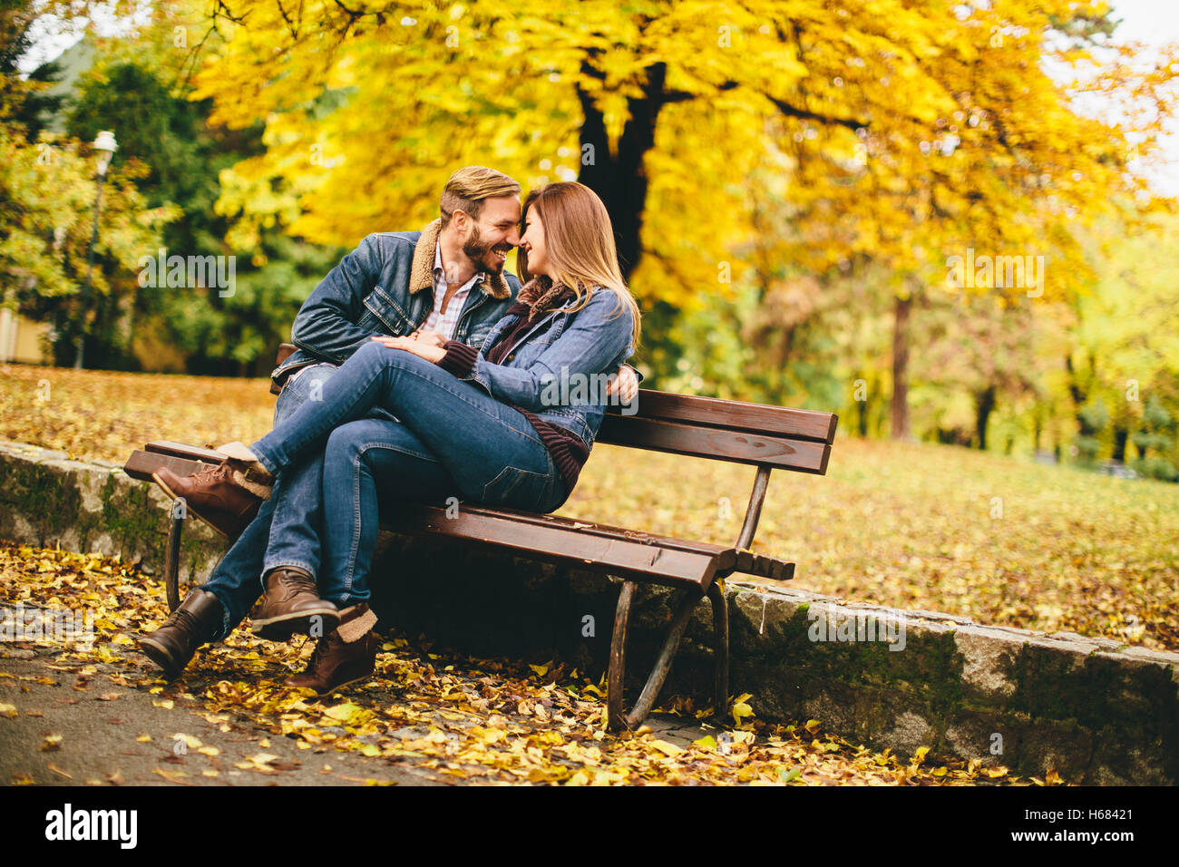 Loving and romantic couple on a bench in the autumn park Stock Photo ...