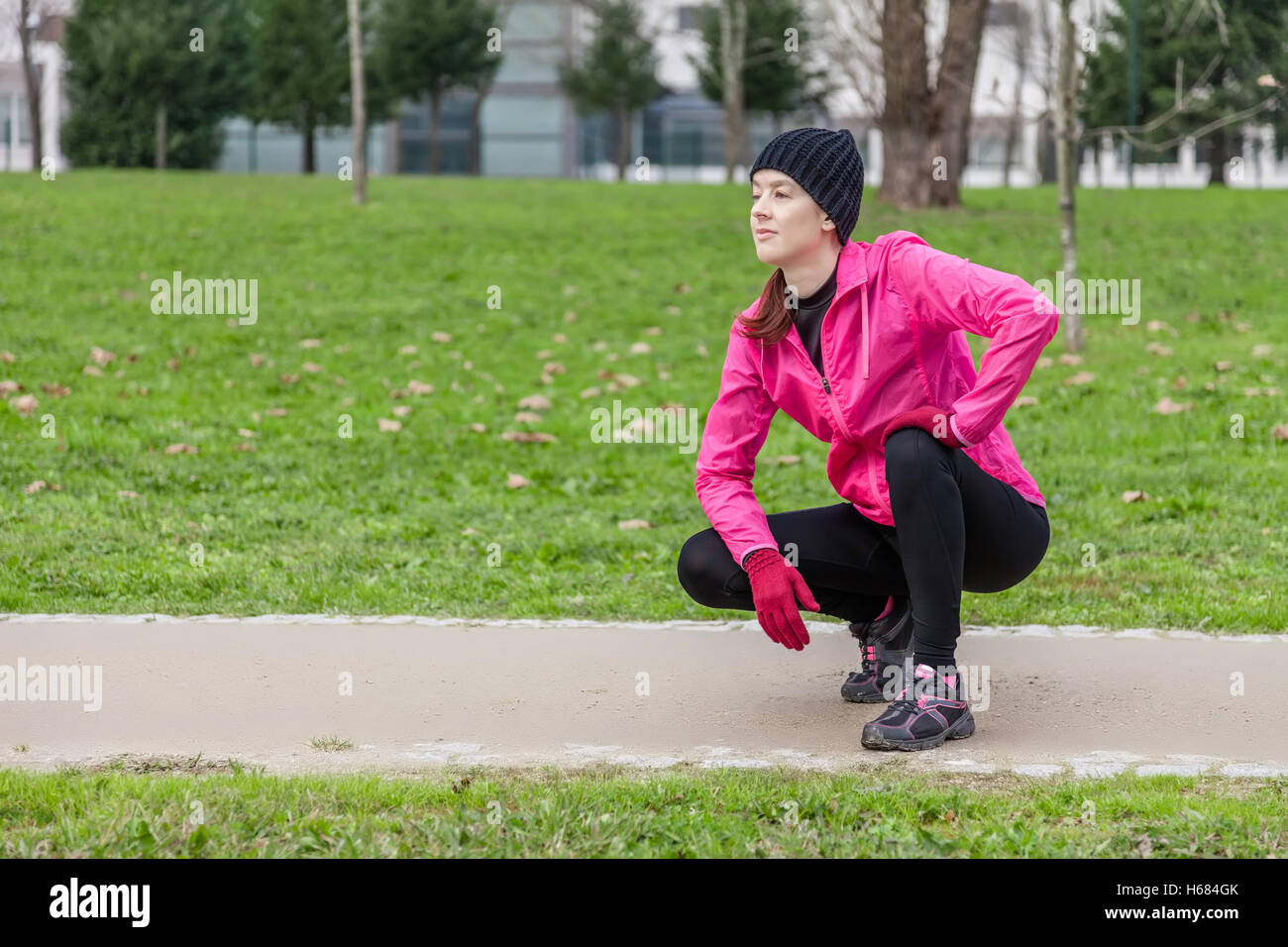 Young female athlete analyzing the track before running on a cold ...