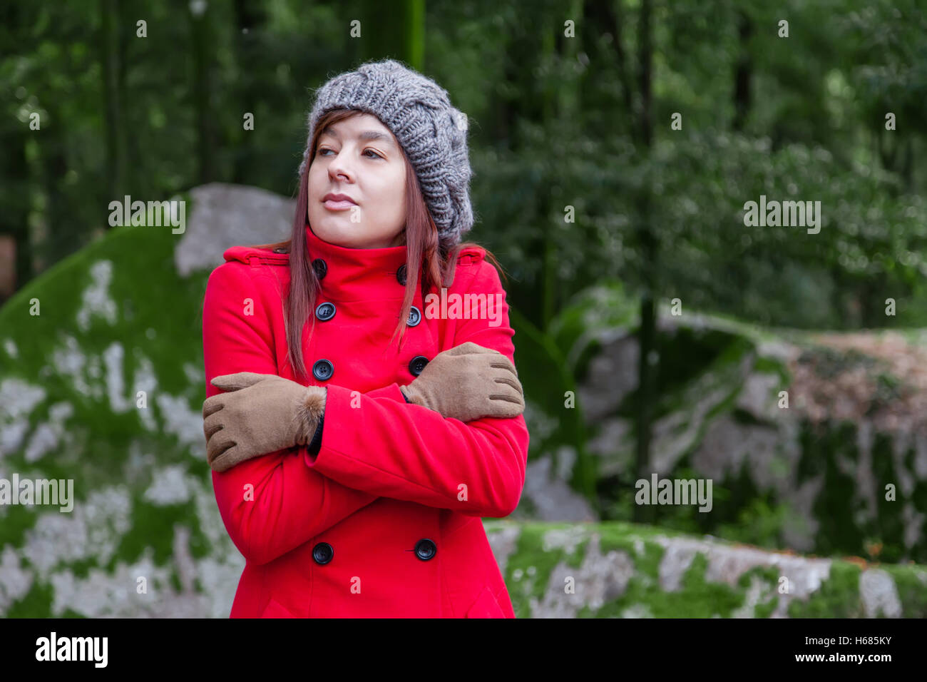Young woman shivering with cold and embracing herself on a forest ...