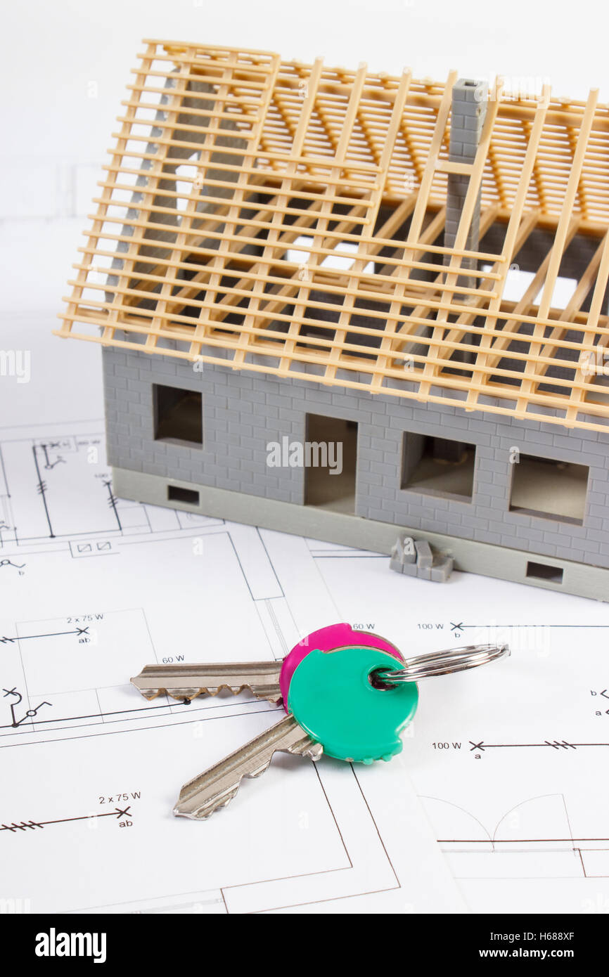 Home keys and small house under construction lying on electrical ...